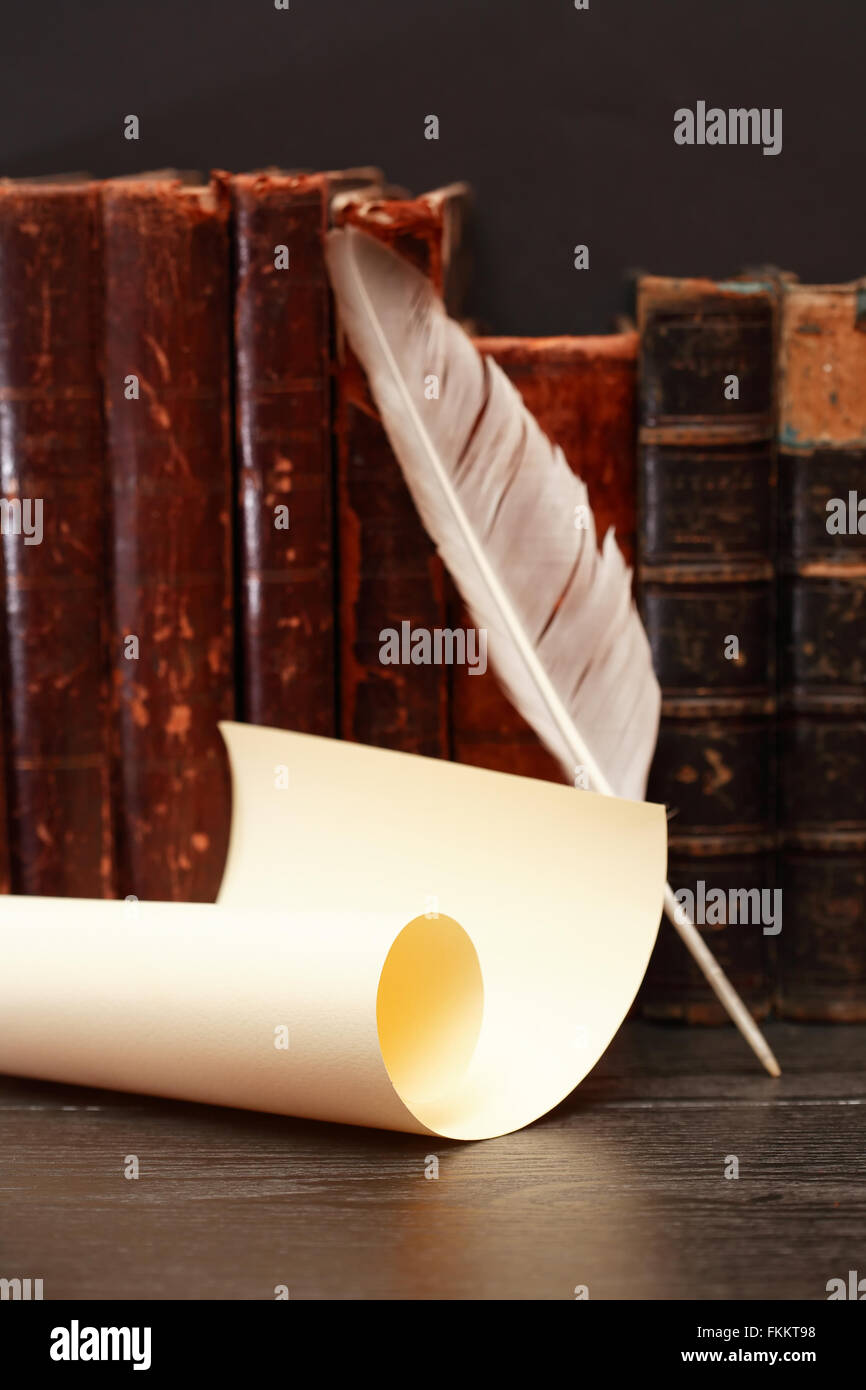 Ancient literature. Quill near scroll on background with old books ...