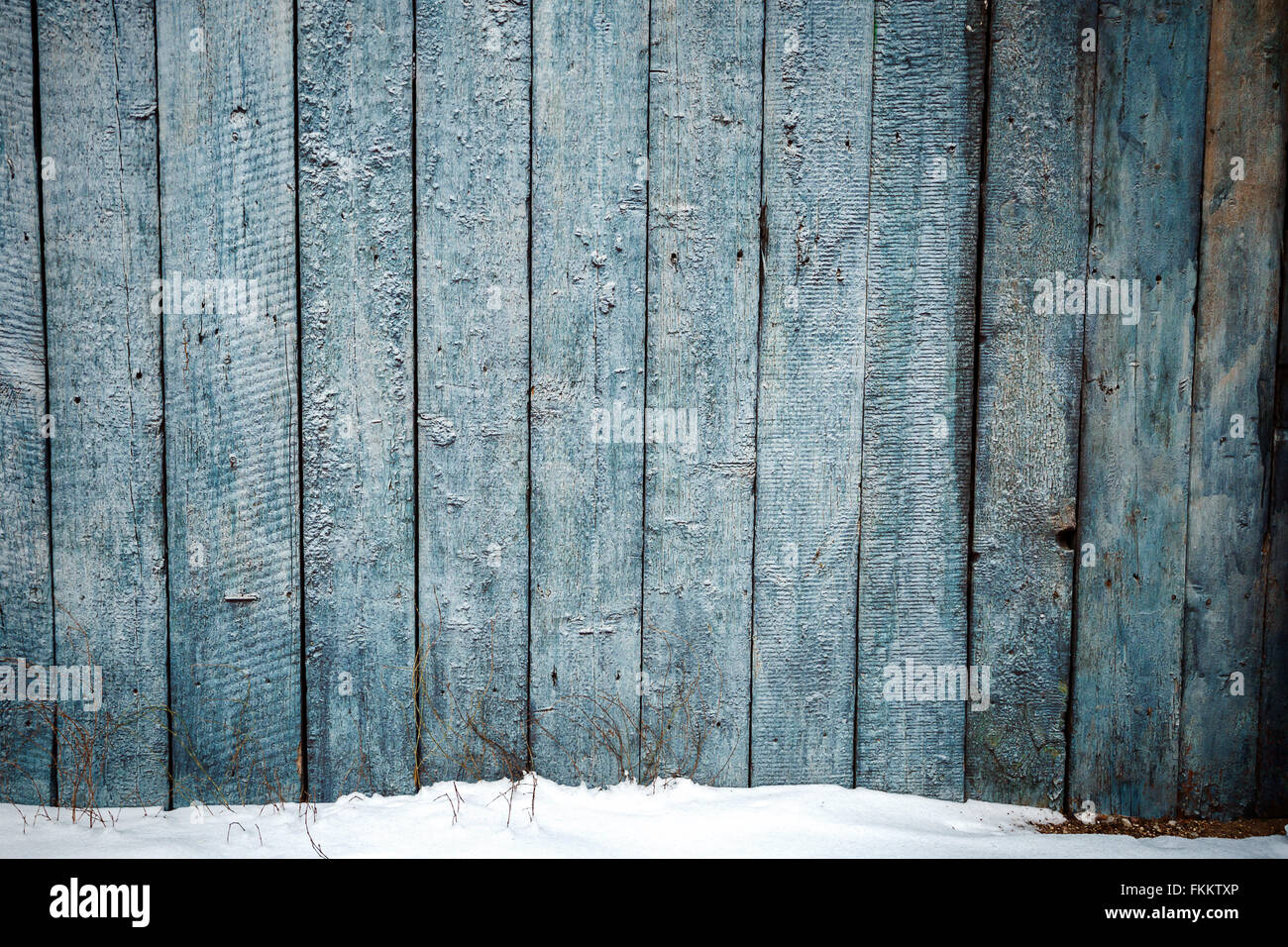 Old weathered wood plank fence and a ground covered with snow Stock ...