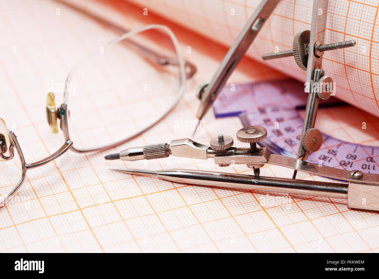 Set of drawing instrument and rulers near spectacles on graph paper ...