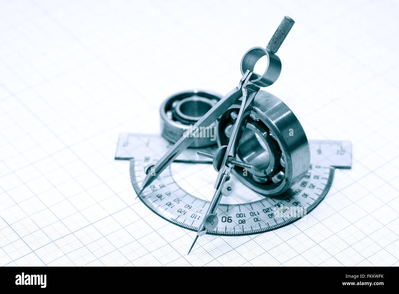Industrial concept. Divider and ruler near ball bearing on graph paper ...