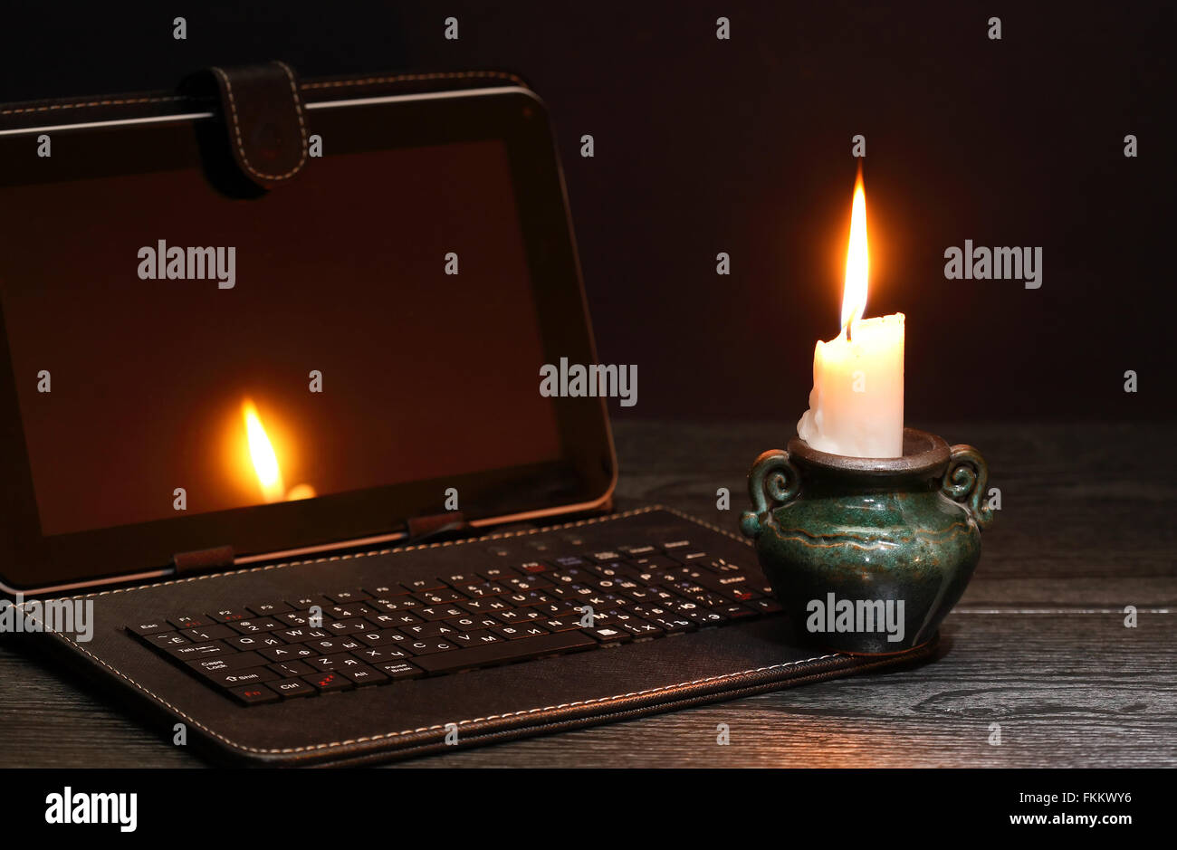 Blackout concept. Lighting candle near laptop with dark empty screen ...