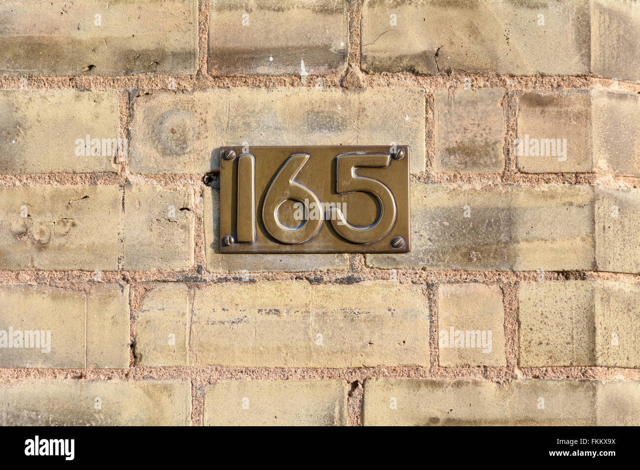 House number 165 brass sign on wall Stock Photo - Alamy