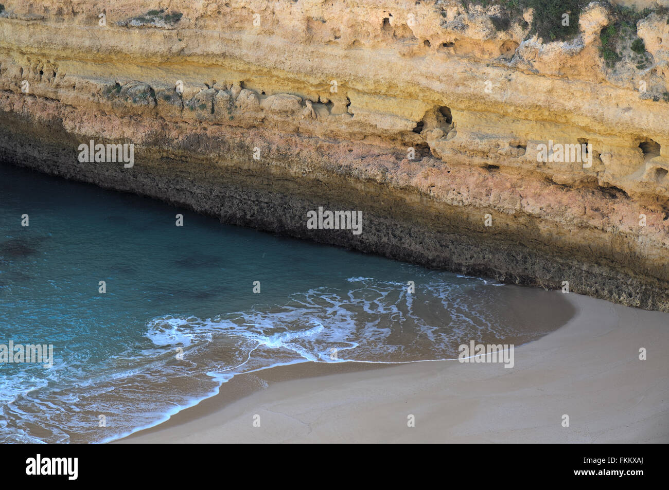 Beach waves lightly touching the sands in Fontainhas beach. Algarve ...