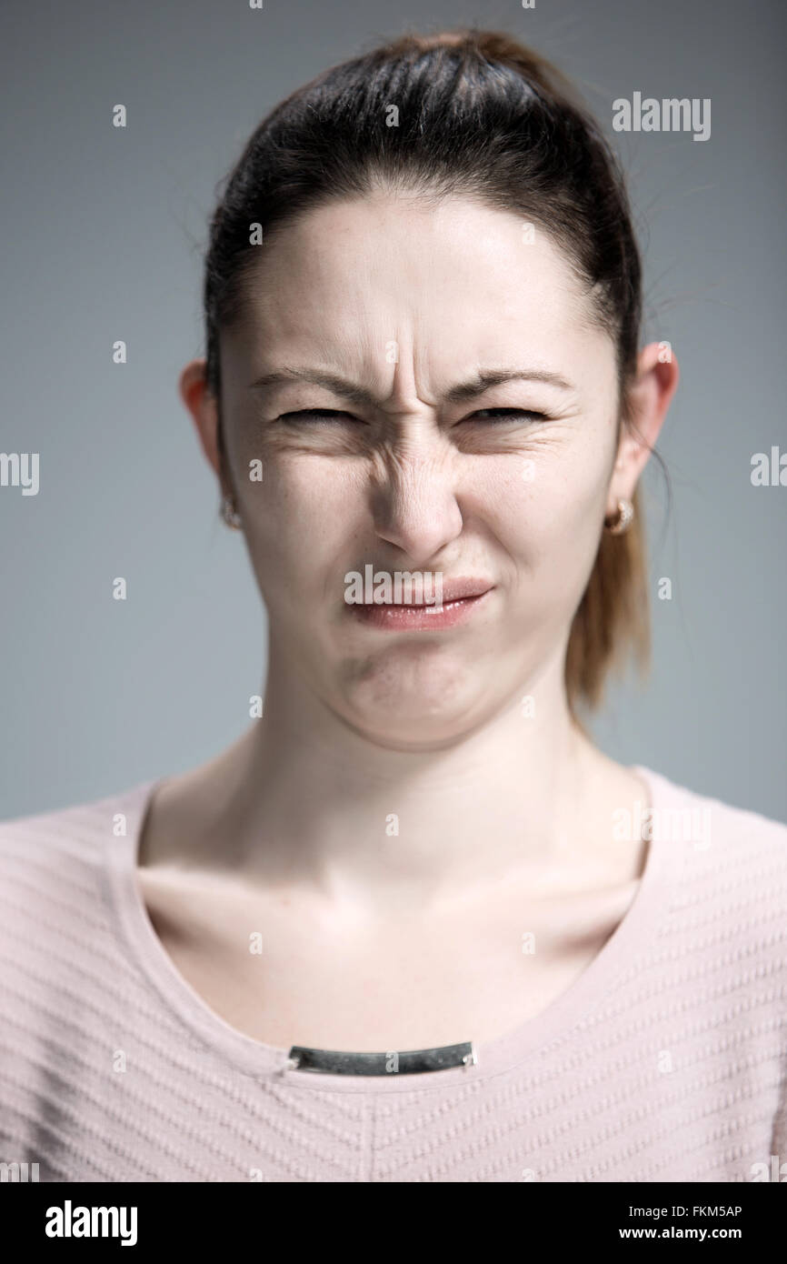The portrait of disgusted woman on gray Stock Photo - Alamy