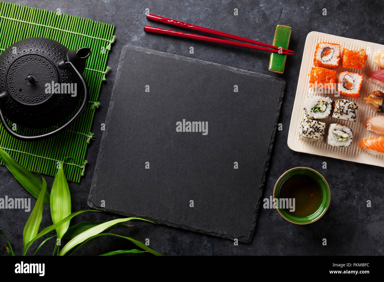 Set of sushi, maki and green tea on stone table. Top view with copy ...