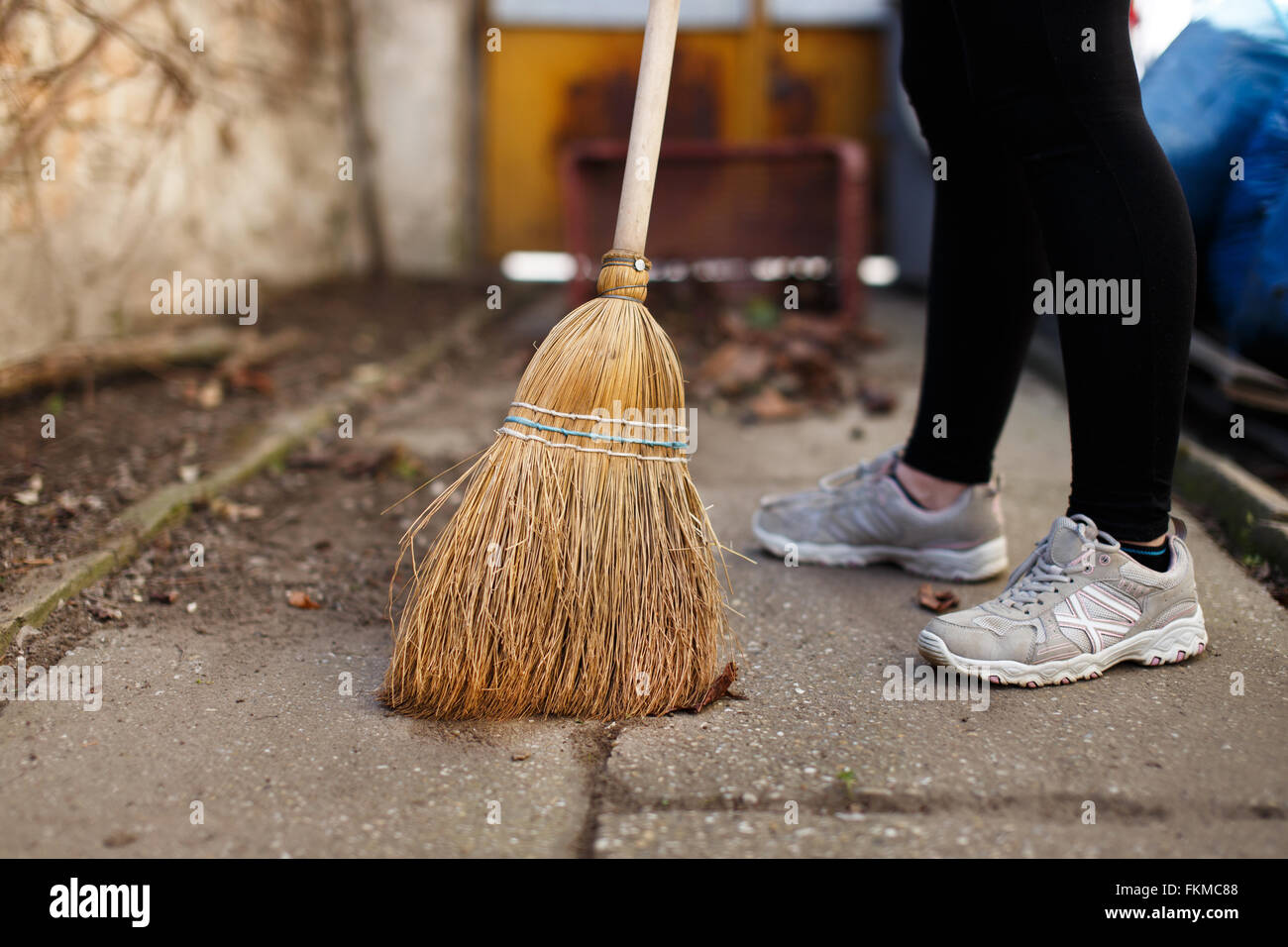 Woman sweep leaves and soil into bin, outdoor works at spring Stock ...