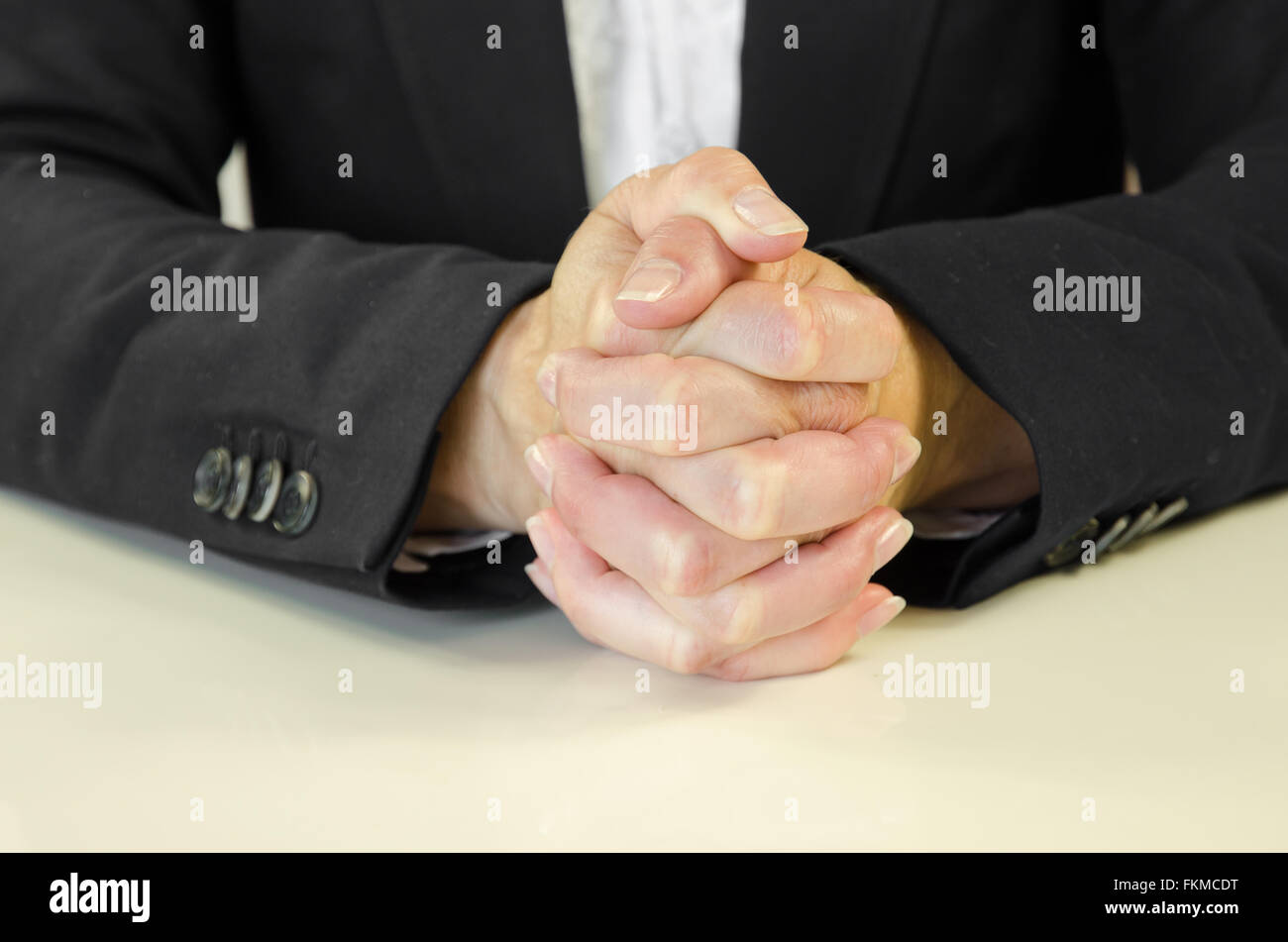 clenched hands over white office desk Stock Photo - Alamy