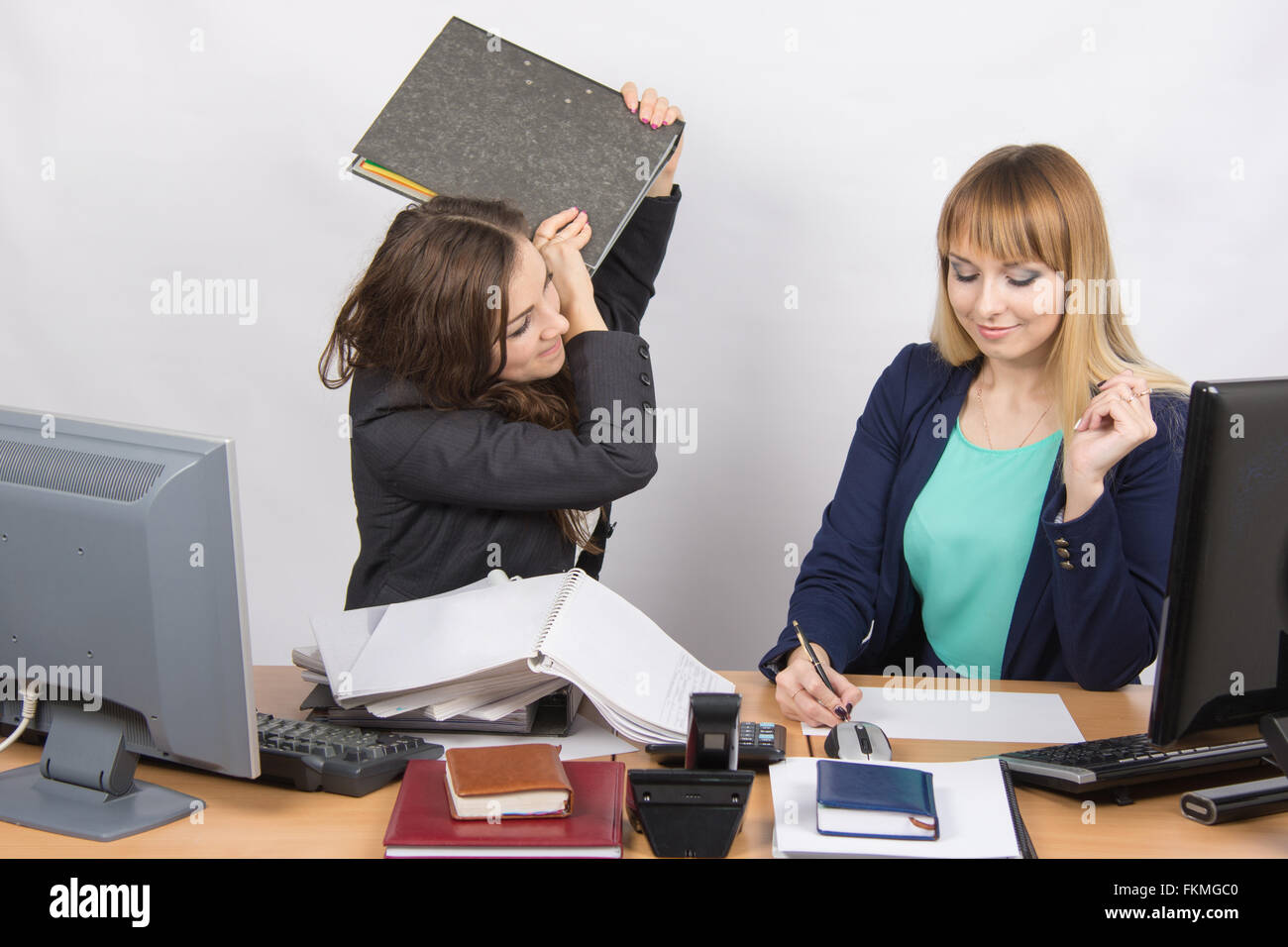 Girl in office with folder anger trying to hit his colleague Stock ...