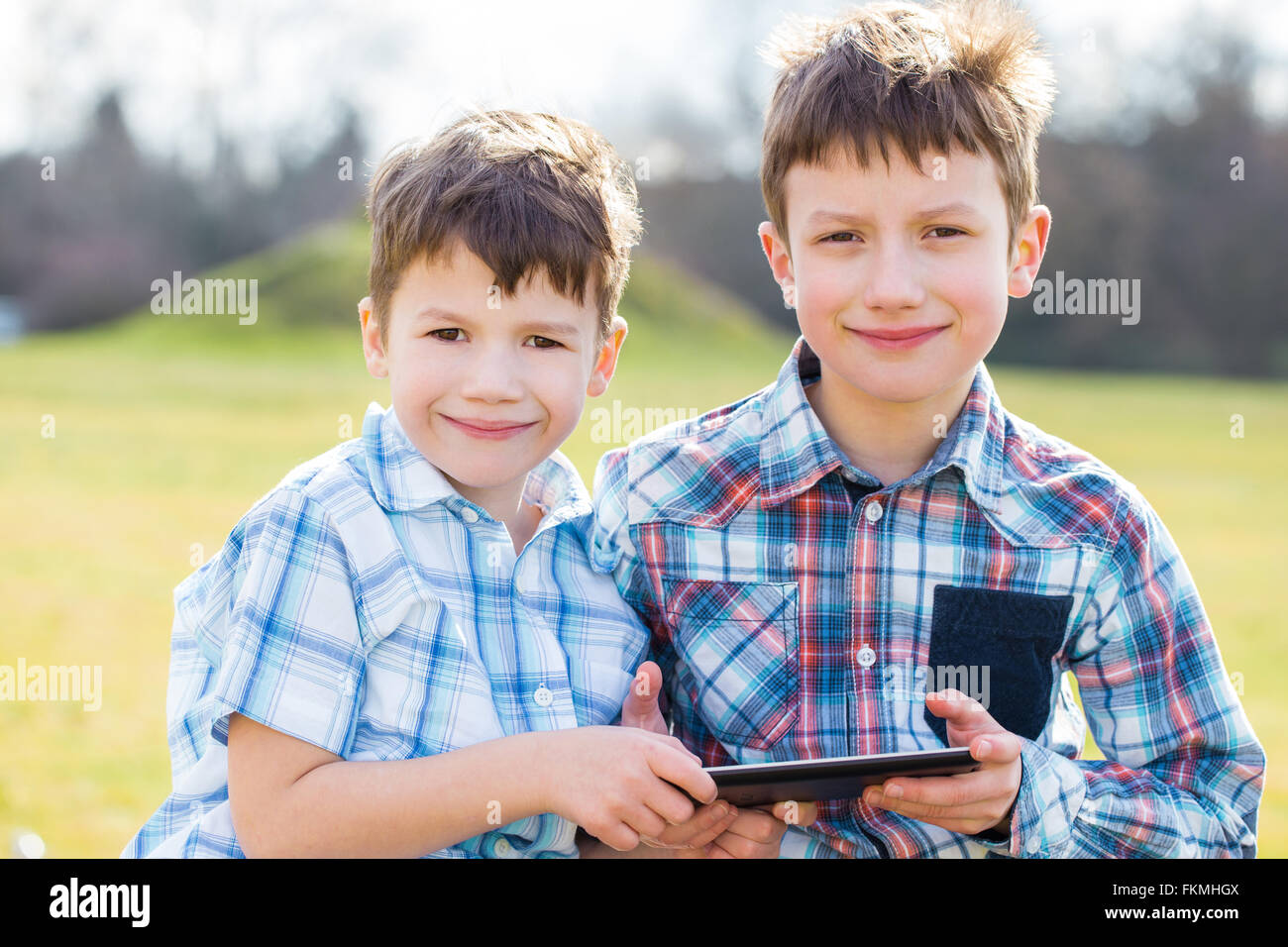 Little boys holding tablet outdoor in nature Stock Photo - Alamy