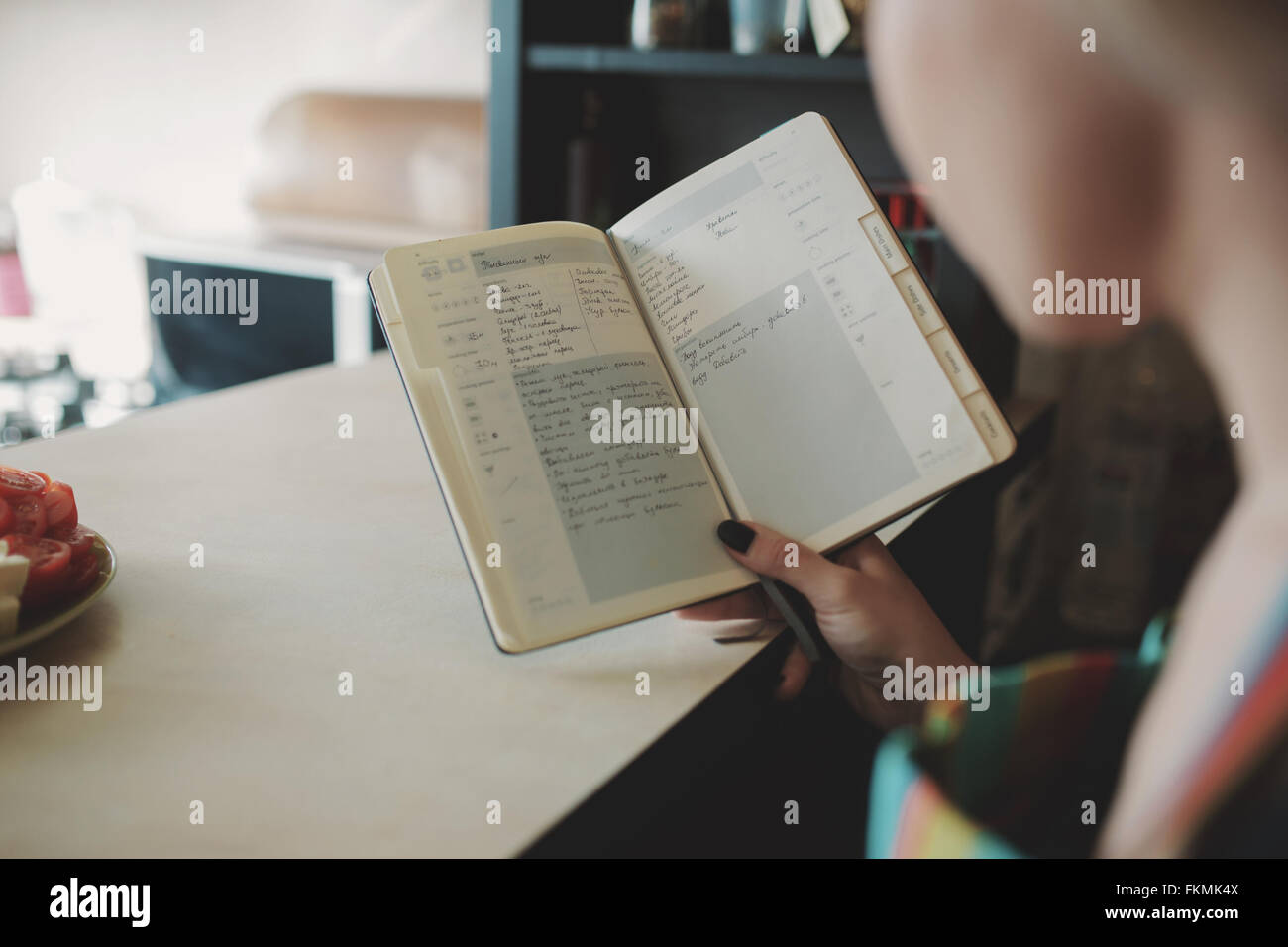 Young woman looking up in a recipes book Stock Photo - Alamy