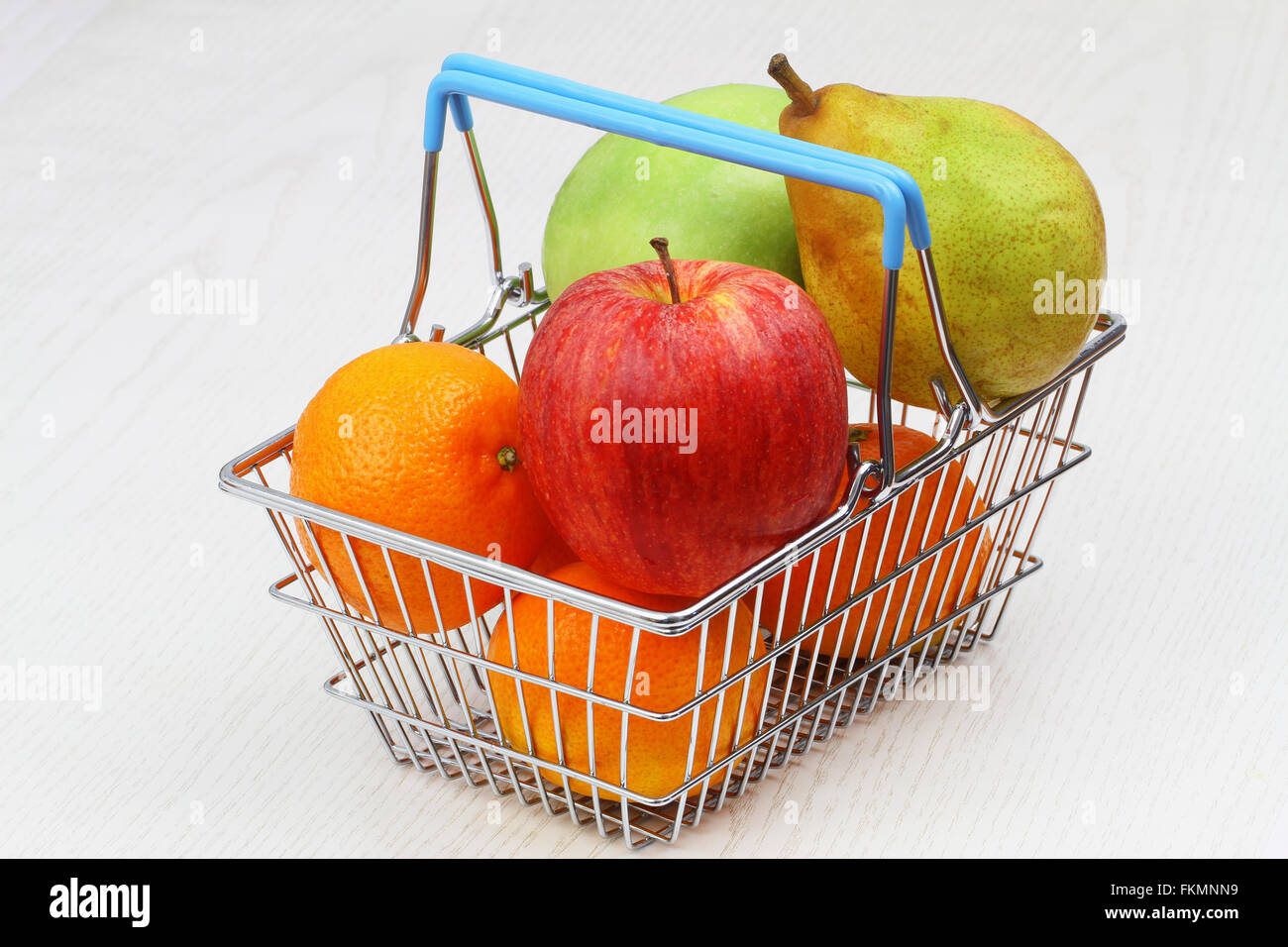 Miniature shopping basket containing fresh fruit, apples, pears and ...