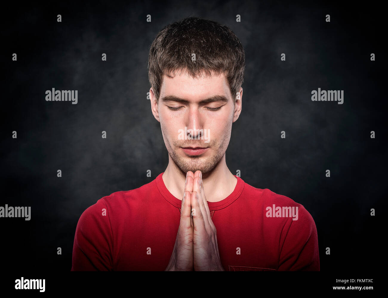 Man praying with hands clasped Stock Photo - Alamy