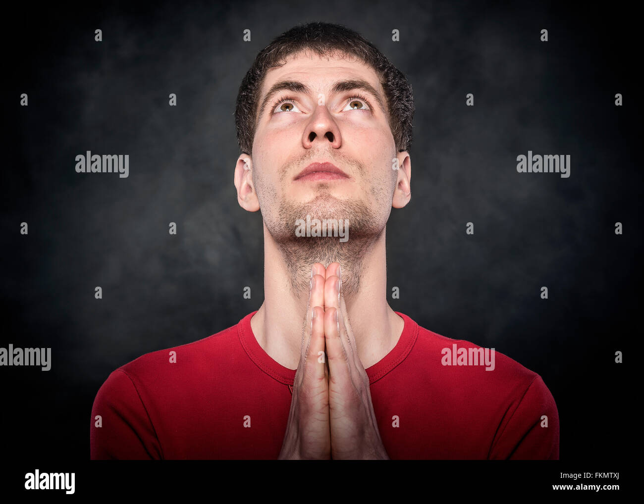 Man praying with hands clasped Stock Photo - Alamy