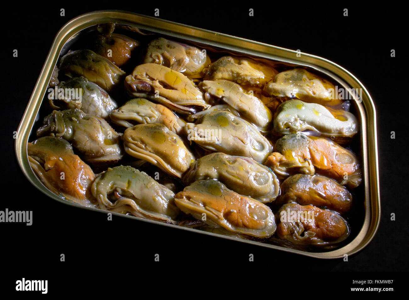 Smoked mussels in vegetable oil on a black background Stock Photo - Alamy