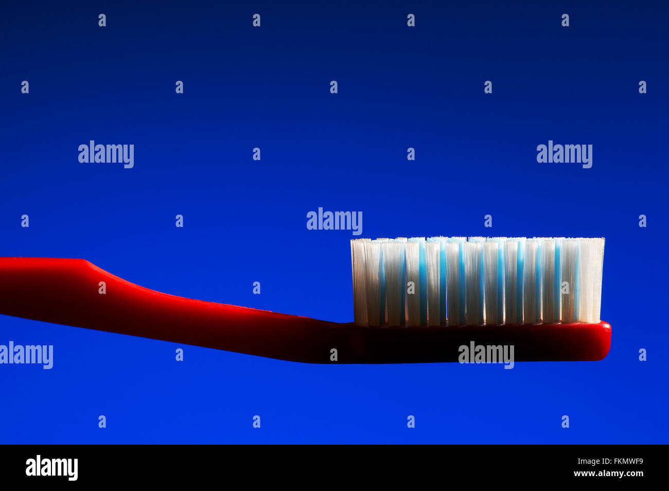 Red tooth-brush on a dark blue background Stock Photo - Alamy