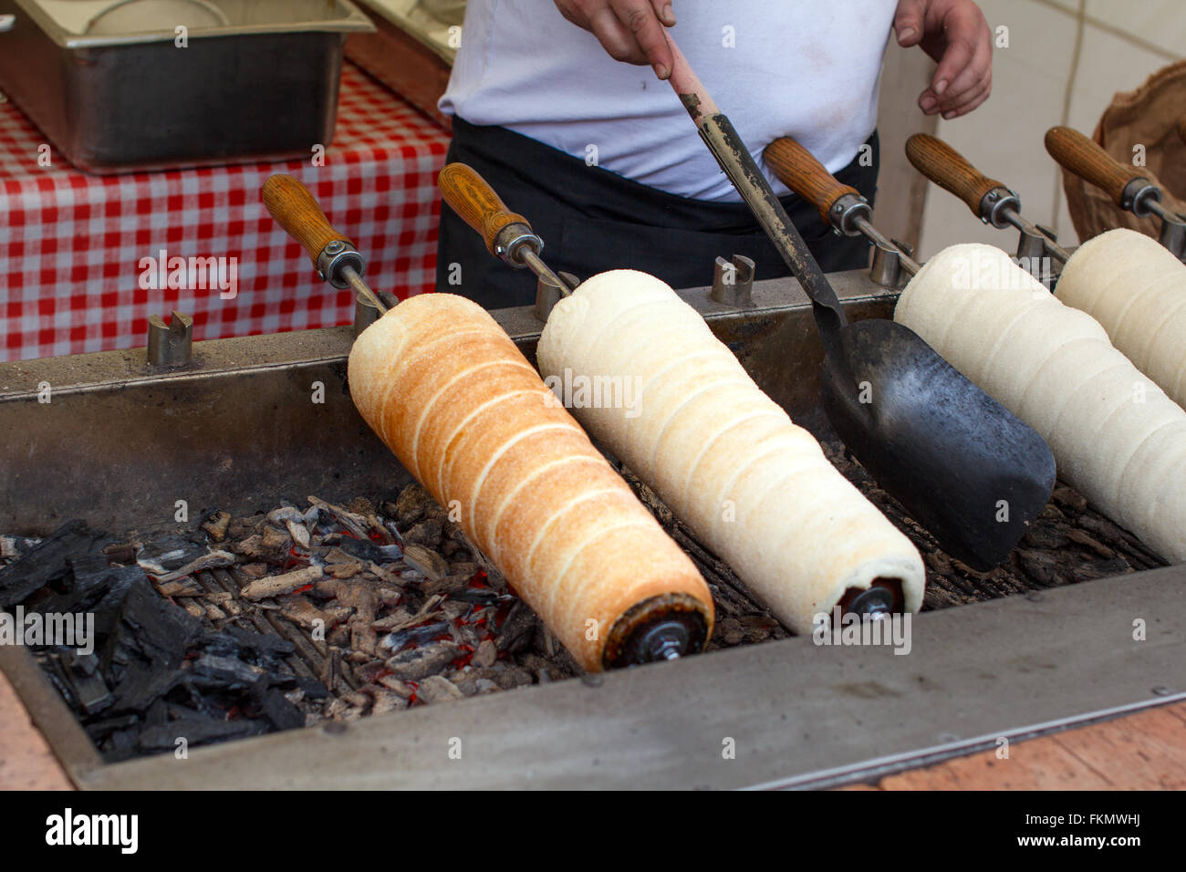 Man baking chimney cake outdoor Stock Photo - Alamy