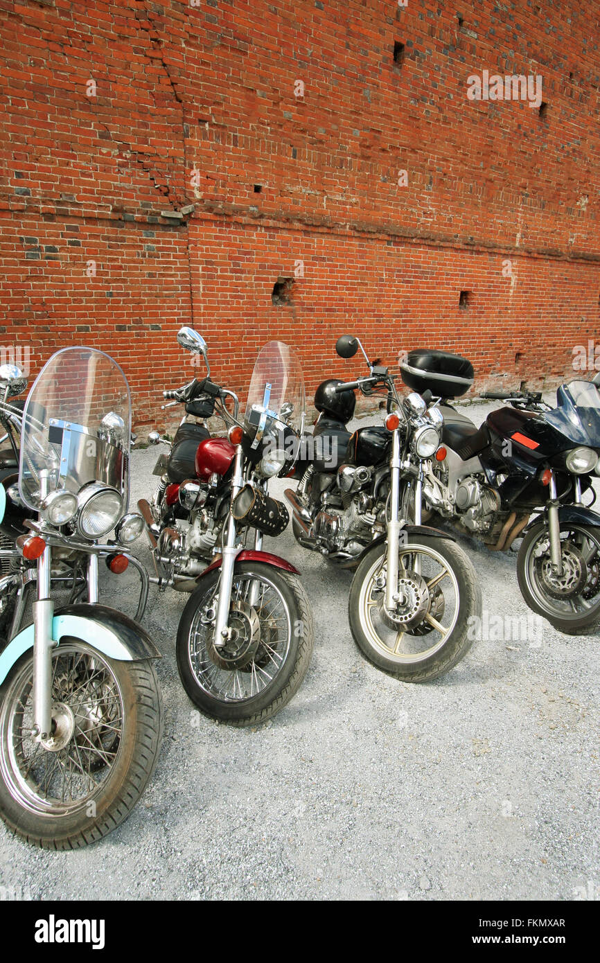 Four motorcycles on a background of a brick wall Stock Photo - Alamy