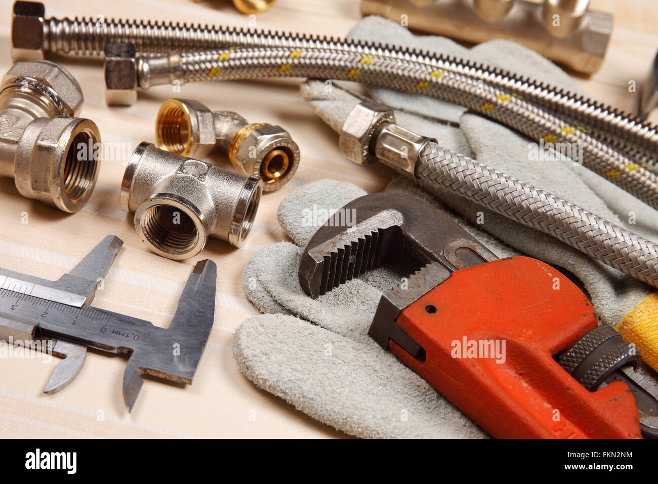 Set of plumbing and tools on the table. Fitting, suede gloves and ...