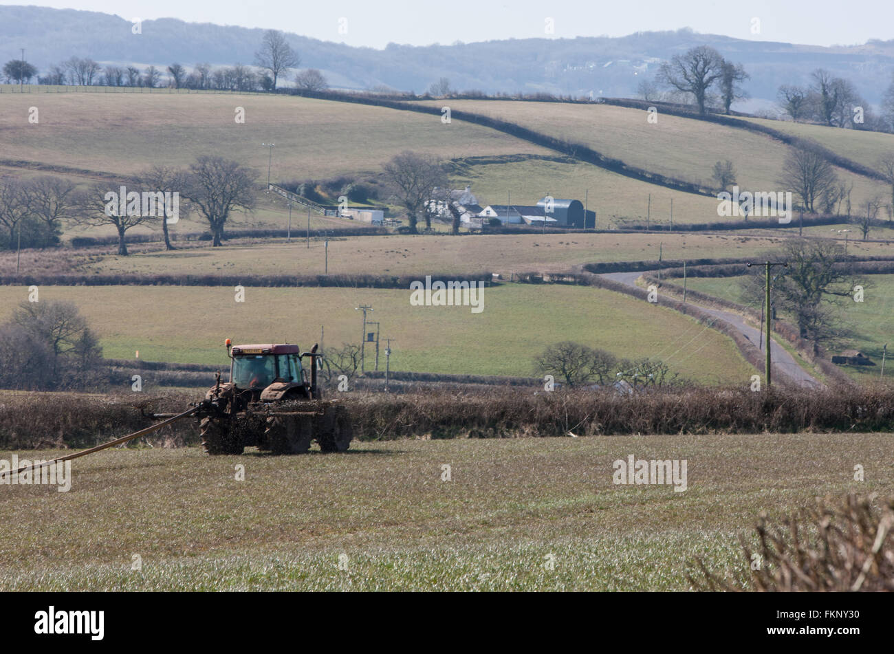 Tractor putting,spraying manure,muck spreading on field near National ...