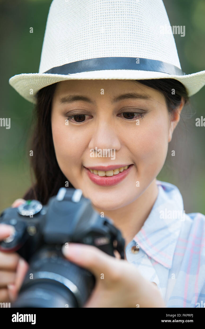 Beautiful asian girl smiling with digital camera photographing, outdoor ...