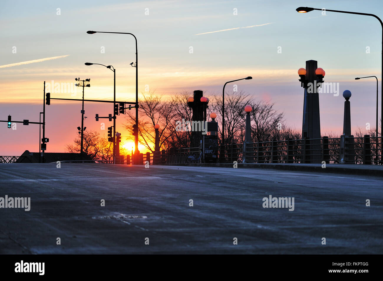 A muted sun rises over Lake Michigan and above the 31st Street Bridge ...