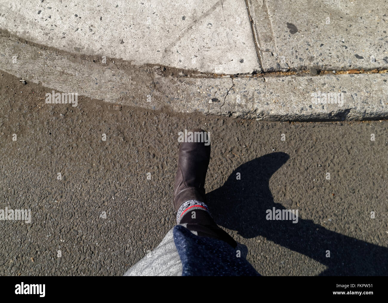 Woman's foot in boots about to step on a concrete sidewalk Stock Photo ...