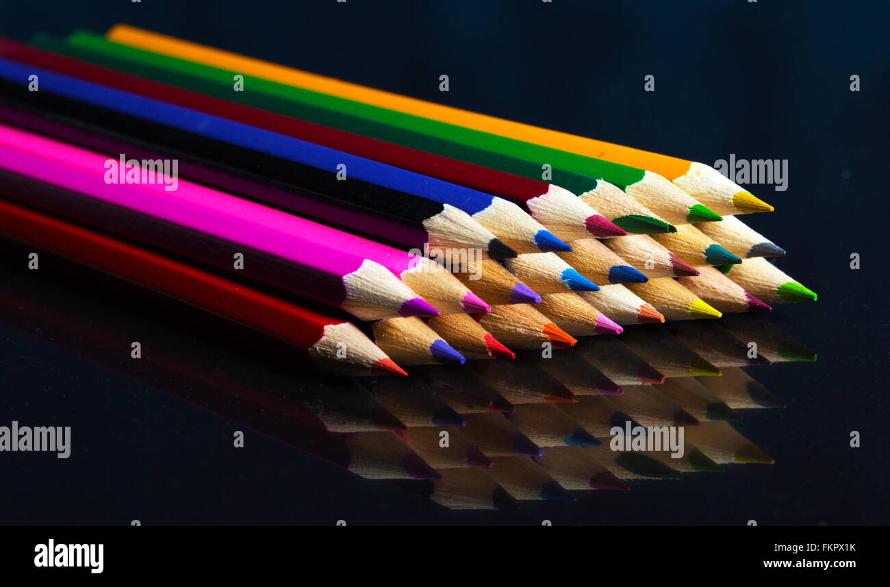 Coloured art crayons on tile showing reflection Stock Photo - Alamy