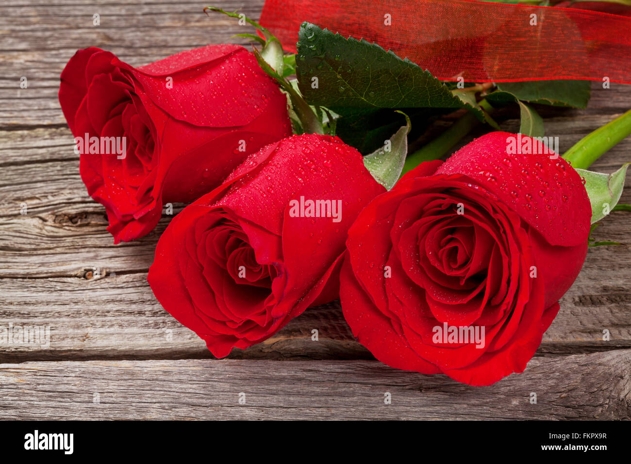 Red roses over wooden table Stock Photo - Alamy