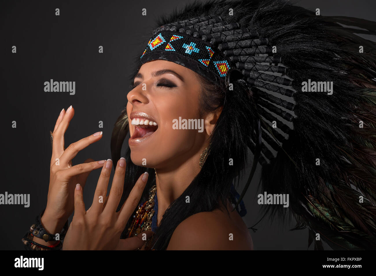Portrait of screaming beautiful woman in costume of American Indian ...