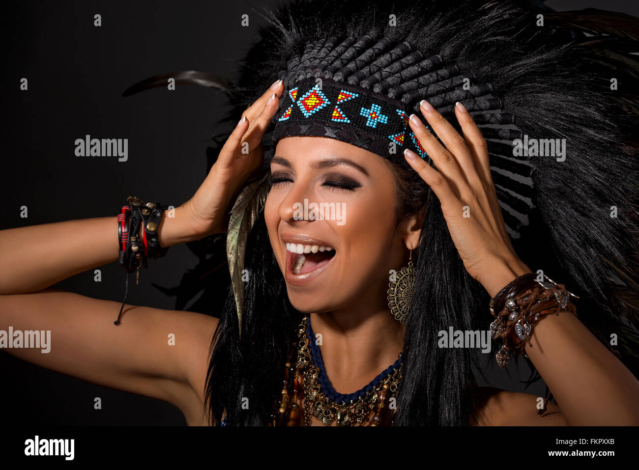 Portrait of screaming beautiful woman in costume of American Indian ...