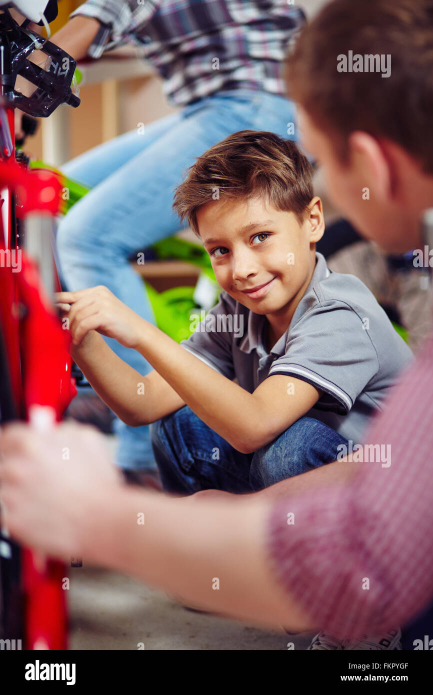 Cute boy learning to repair his bike Stock Photo - Alamy