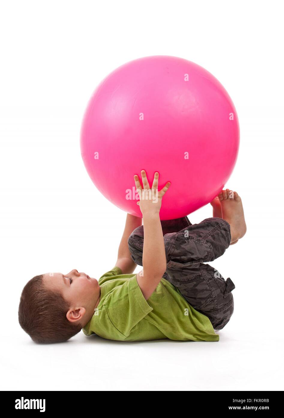 Little boy doing gymnastic exercises with a large rubber ball Stock ...