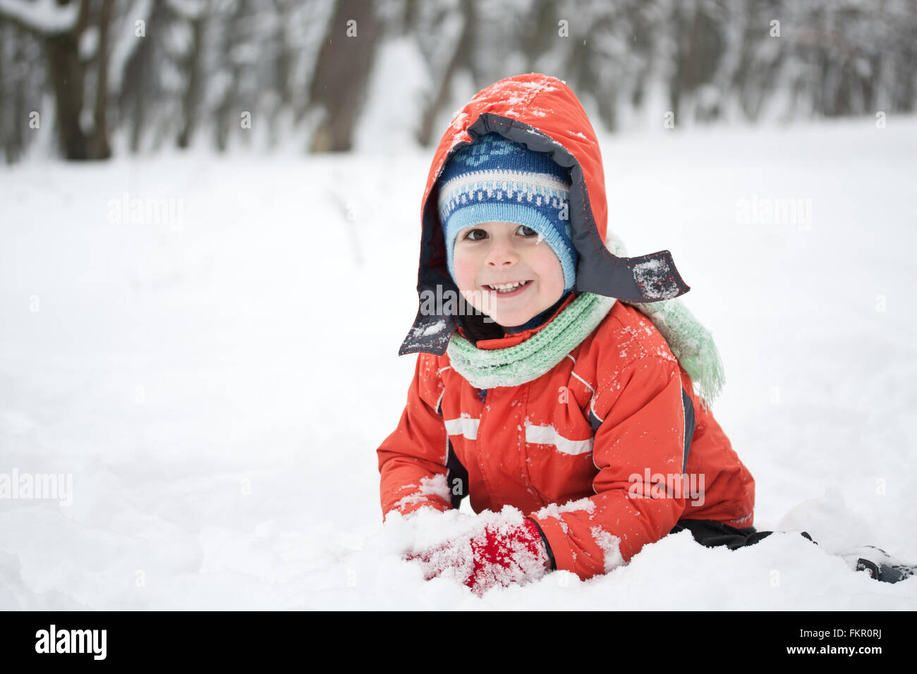 Portrait of little happy boy sitting in snow Stock Photo - Alamy