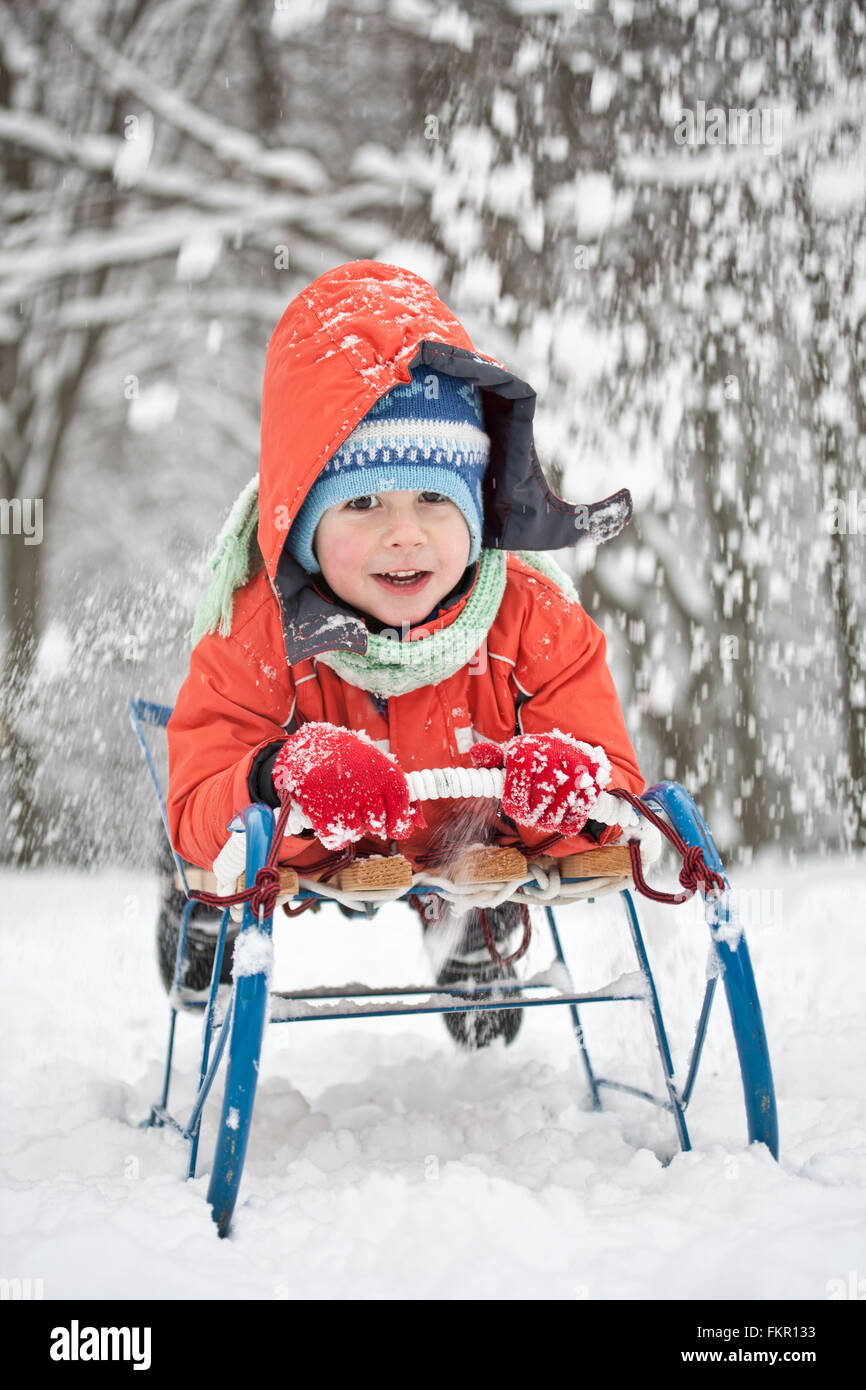 Little boy sliding in the snow Stock Photo - Alamy