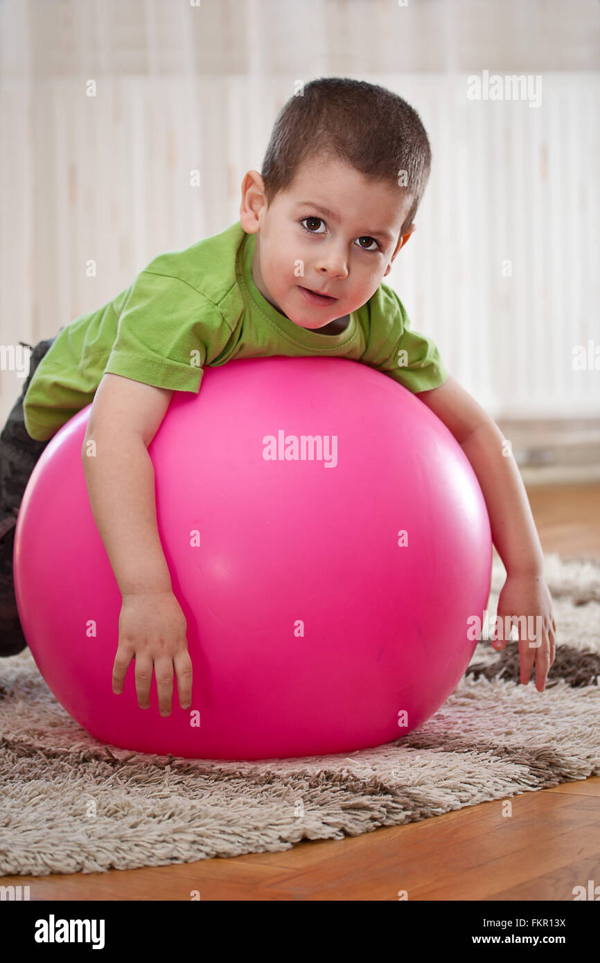 Boy play with large ball in room Stock Photo - Alamy