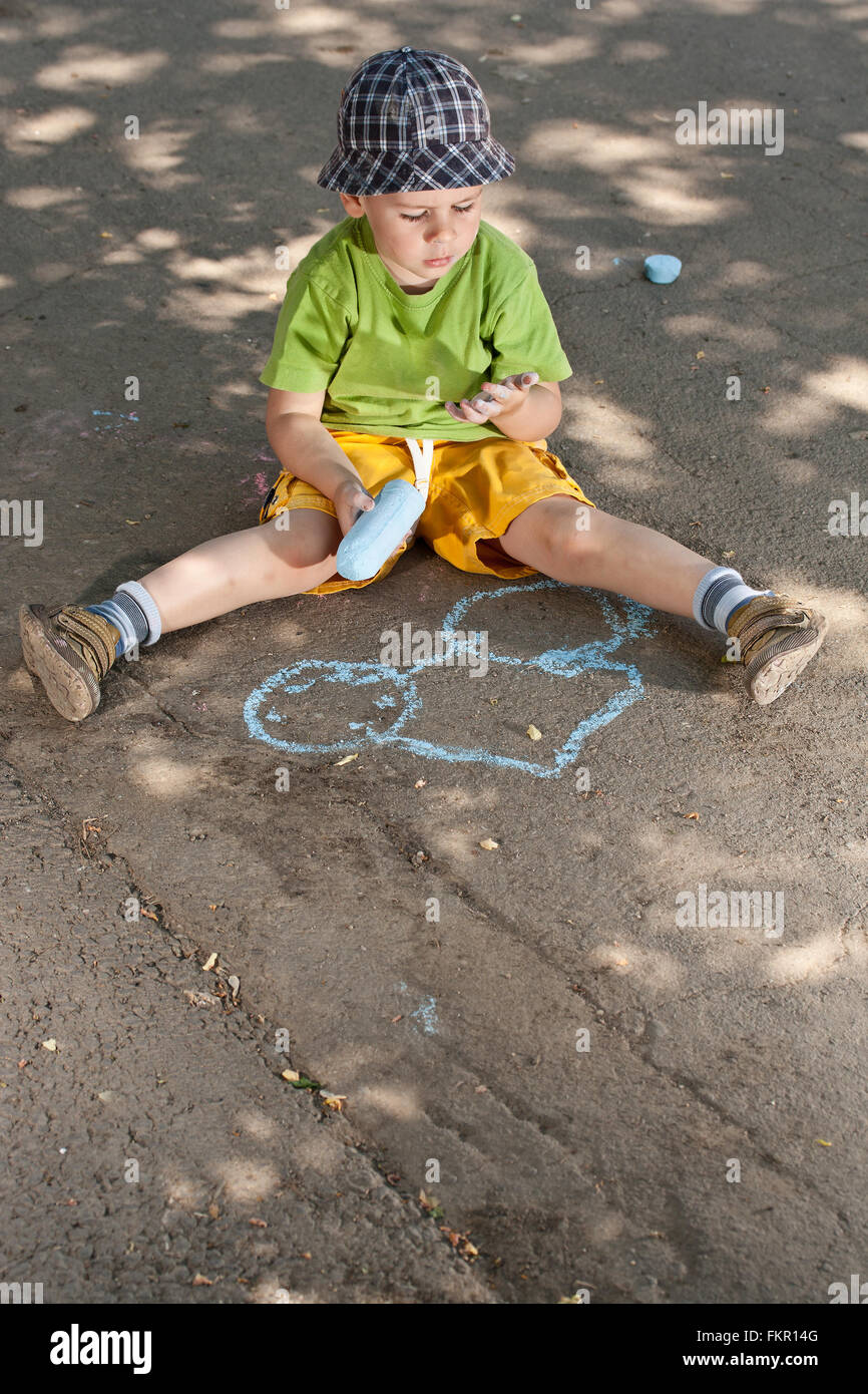 Boy drawing with chalk on asphalt Stock Photo - Alamy