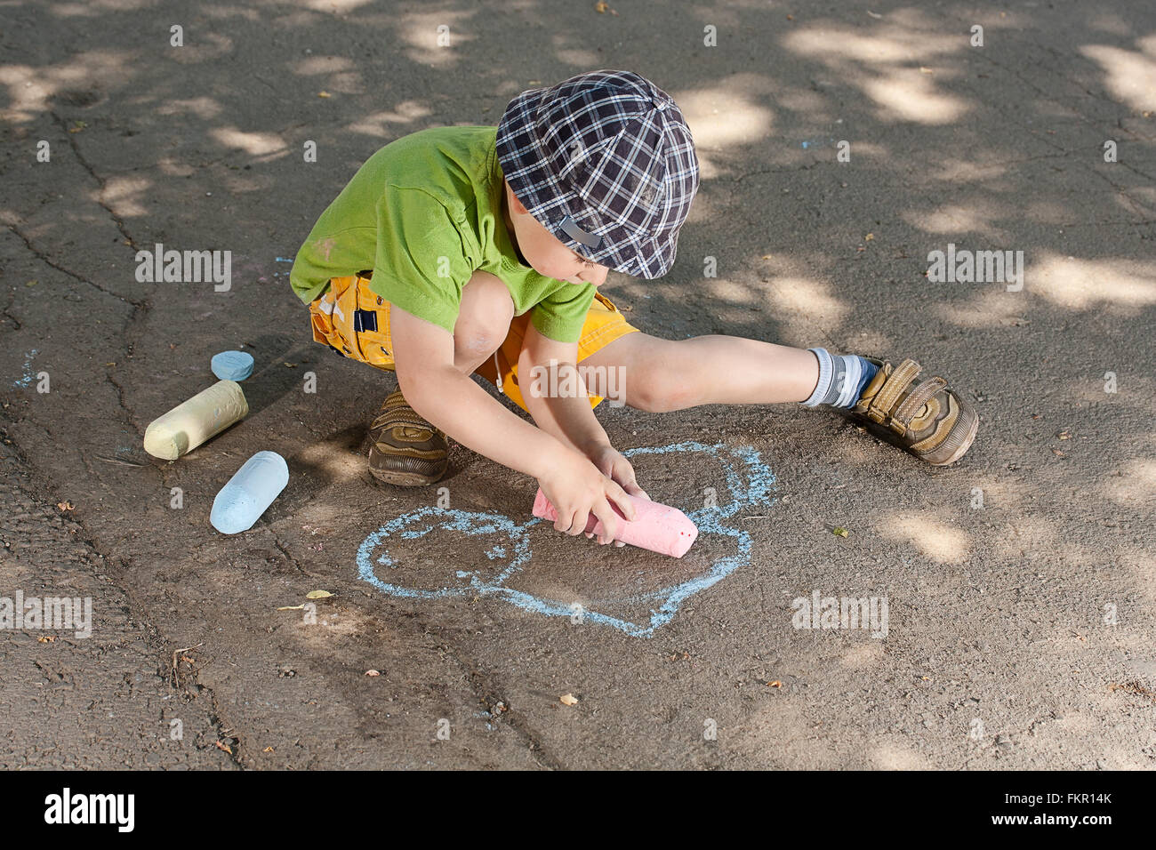 Boy drawing with chalk on asphalt Stock Photo - Alamy