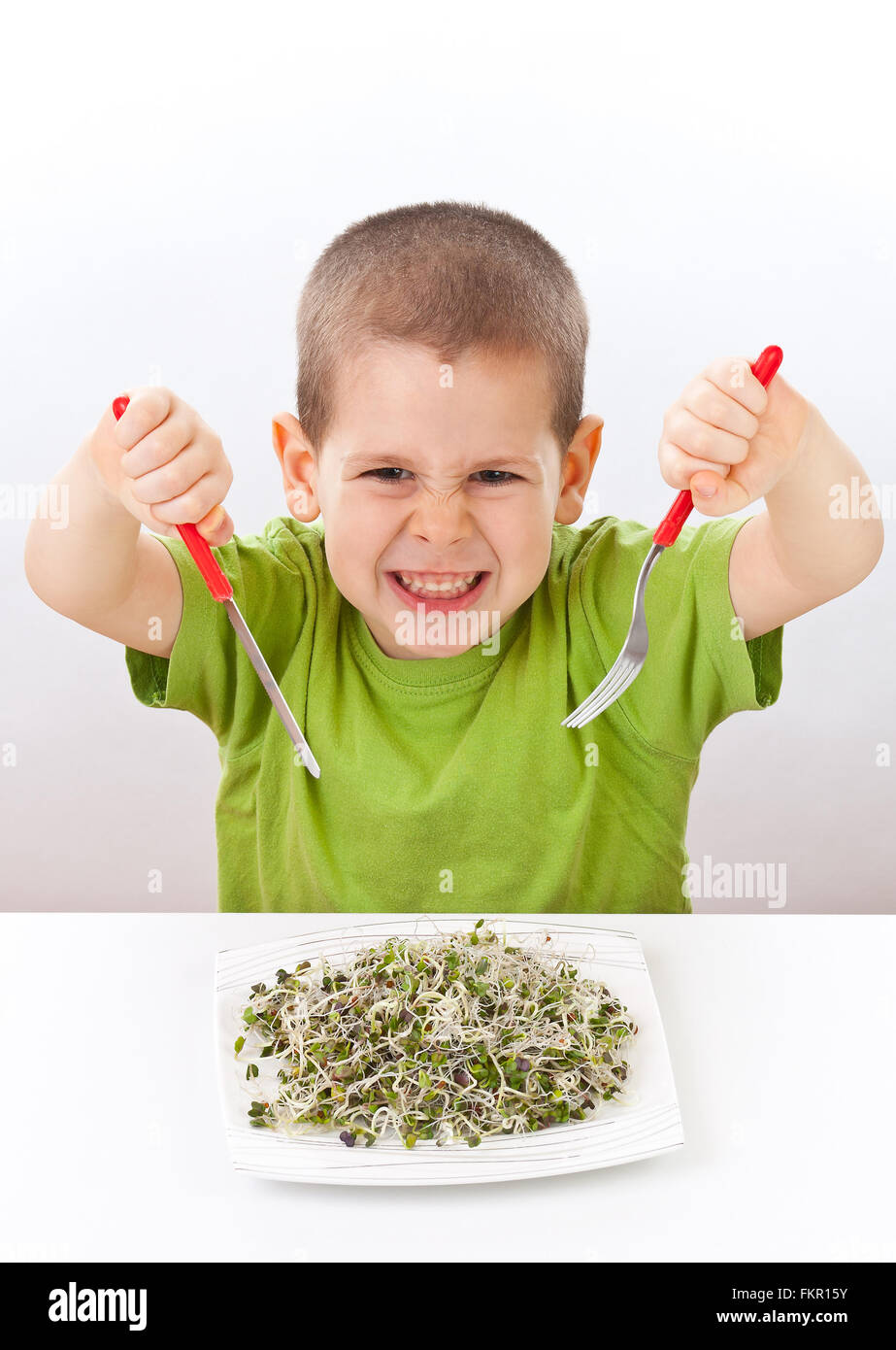 Hungry Boy taking healthy green food, isolated on white Stock Photo - Alamy