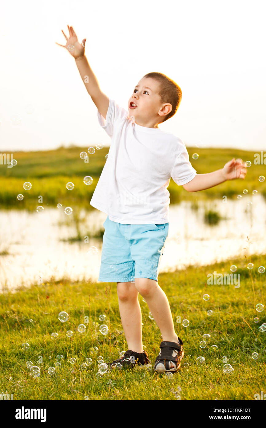 Boy Chasing Bubbles in the park Stock Photo - Alamy