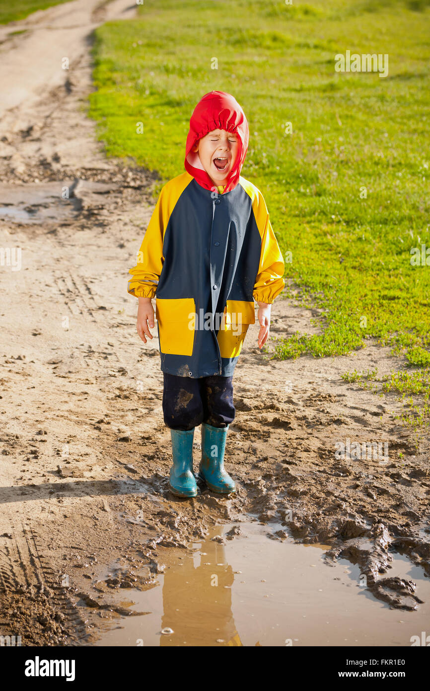 Boy in a muddy puddle screaming Stock Photo - Alamy
