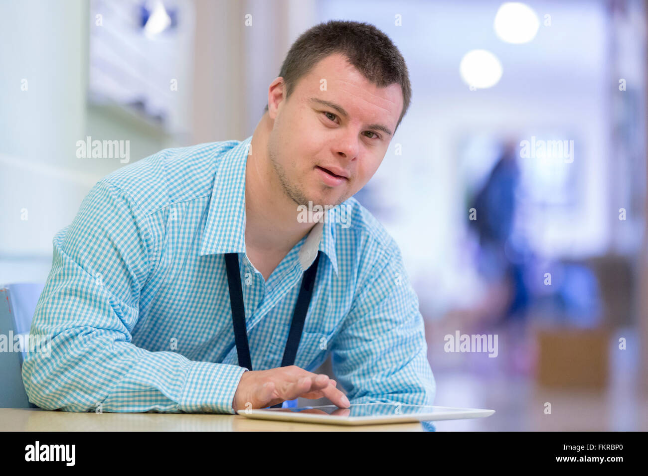 Caucasian man with Down Syndrome using digital tablet in hospital Stock ...