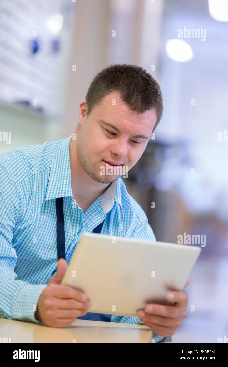Caucasian man with Down Syndrome using digital tablet in hospital Stock ...