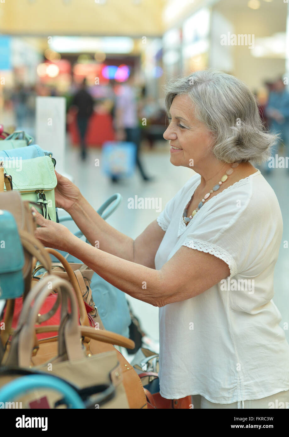 Smiling old lady in store Stock Photo - Alamy