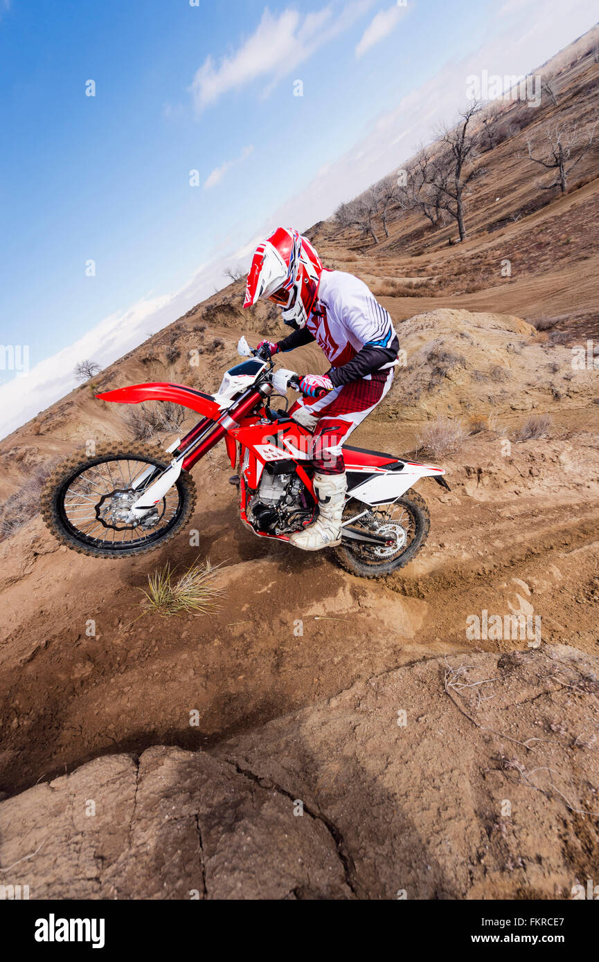Motorcyclist riding dirt bike on hillside Stock Photo - Alamy