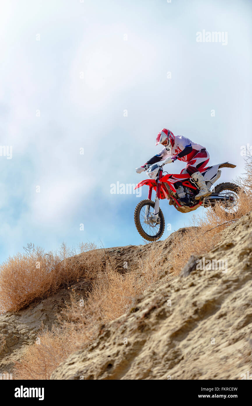 Motorcyclist riding dirt bike on hillside Stock Photo - Alamy