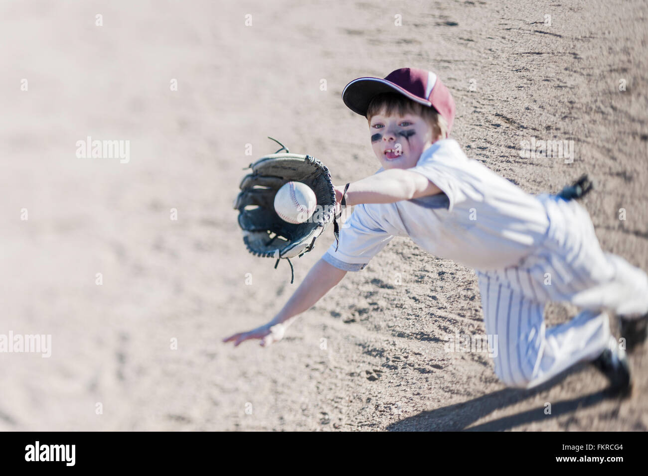 Caucasian boy catching baseball on field Stock Photo - Alamy