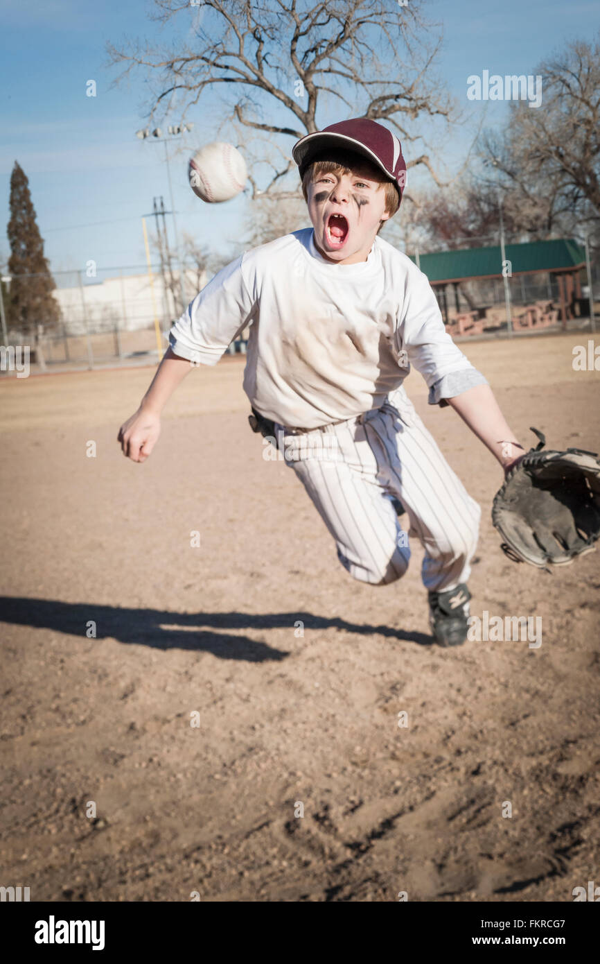 Caucasian boy catching baseball on field Stock Photo - Alamy