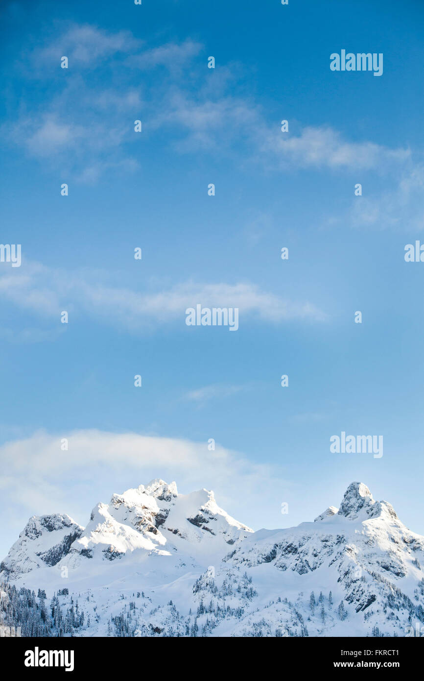 Snowy mountain tops under blue sky Stock Photo - Alamy