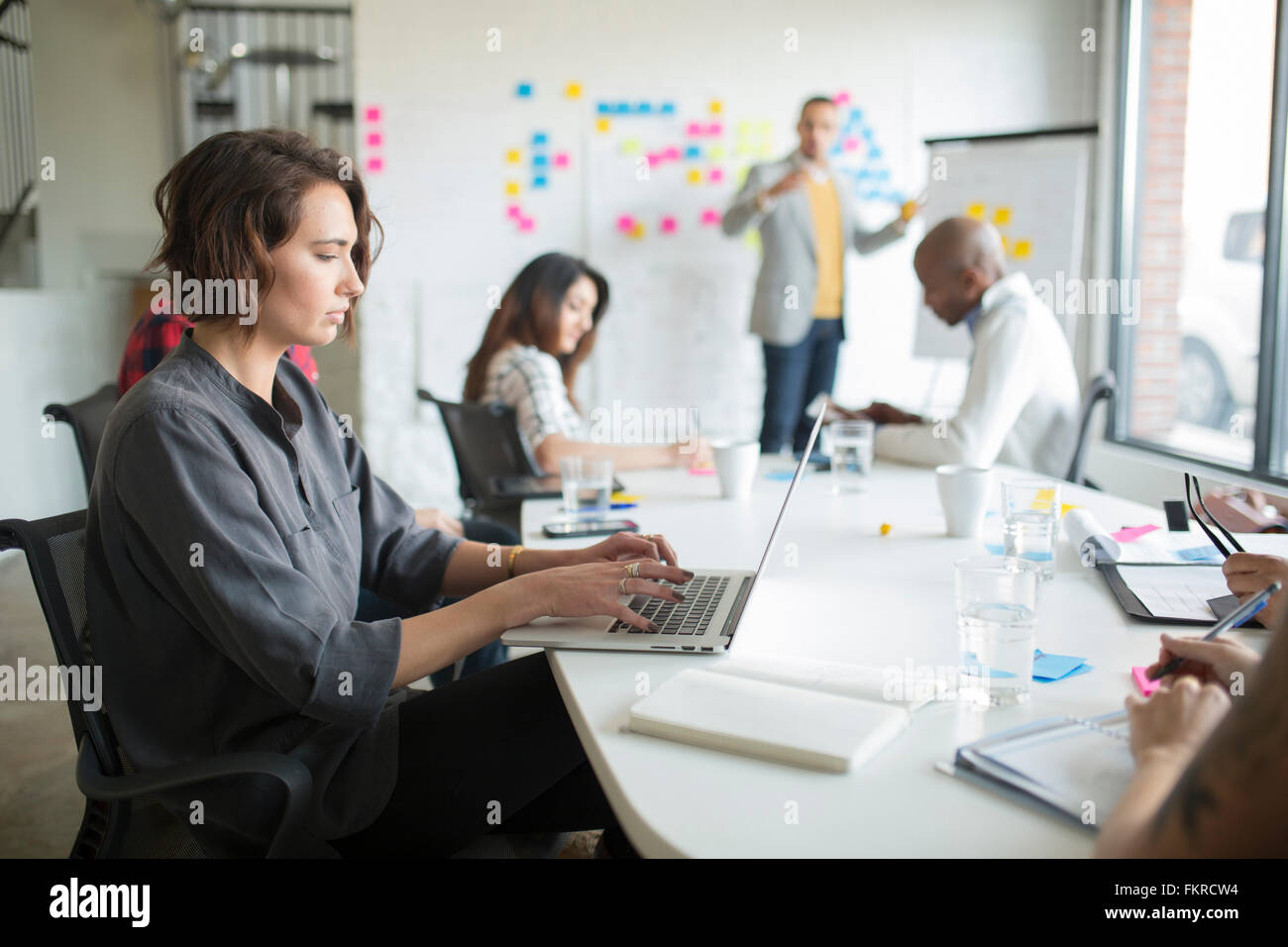 Businesswoman using laptop in office meeting Stock Photo - Alamy
