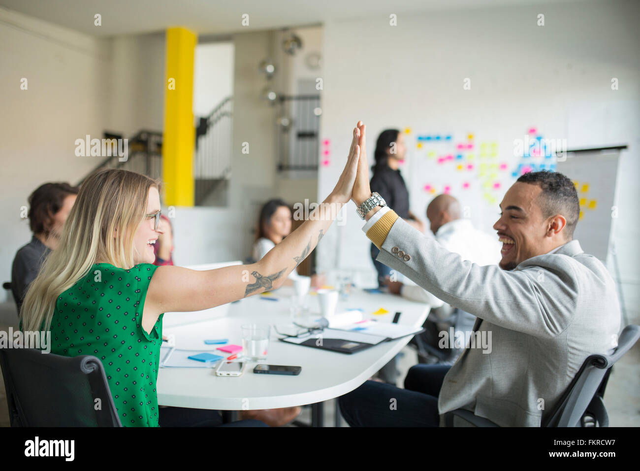 Business people high-fiving in office meeting Stock Photo - Alamy
